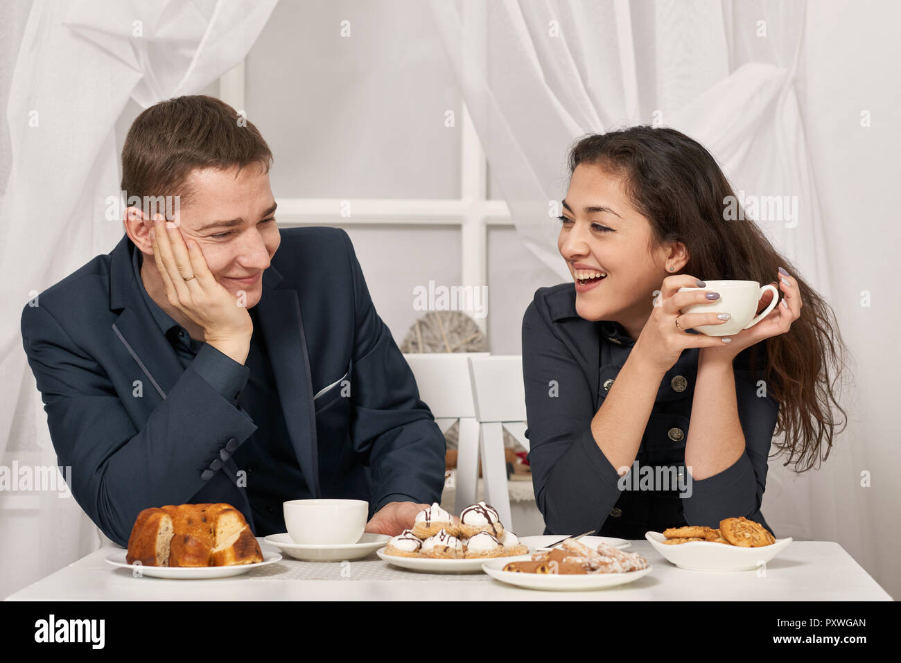 romantic couple drinking tea with cookies and talking Stock Photo - Alamy