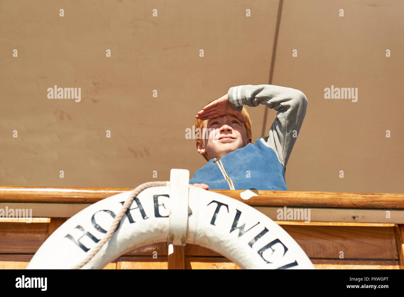 Boy looking over the railing Stock Photo - Alamy