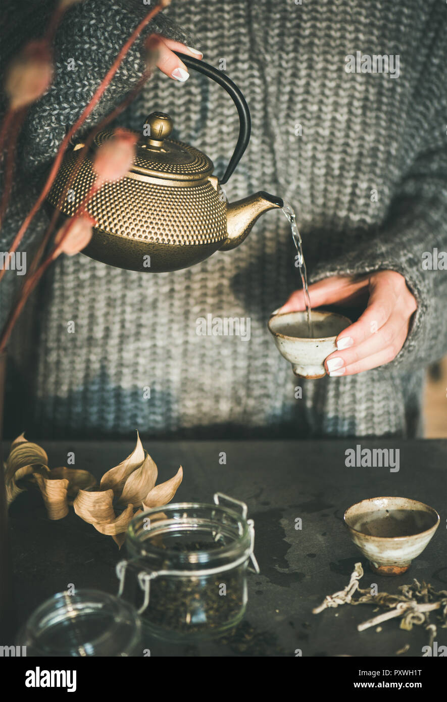 Woman pouring tea from golden teapot into cup Stock Photo - Alamy