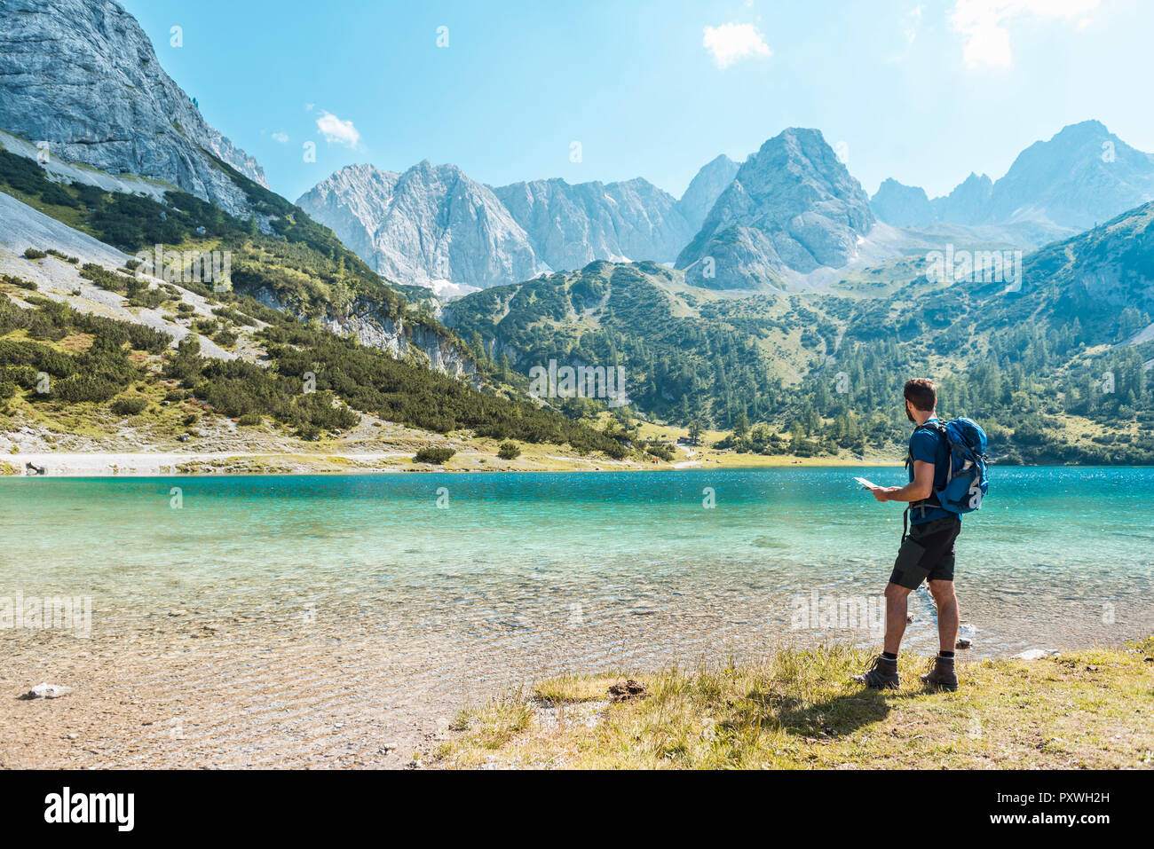 Austria, Tyrol, Man hiking at Seebensee Lake, looking at map Stock ...