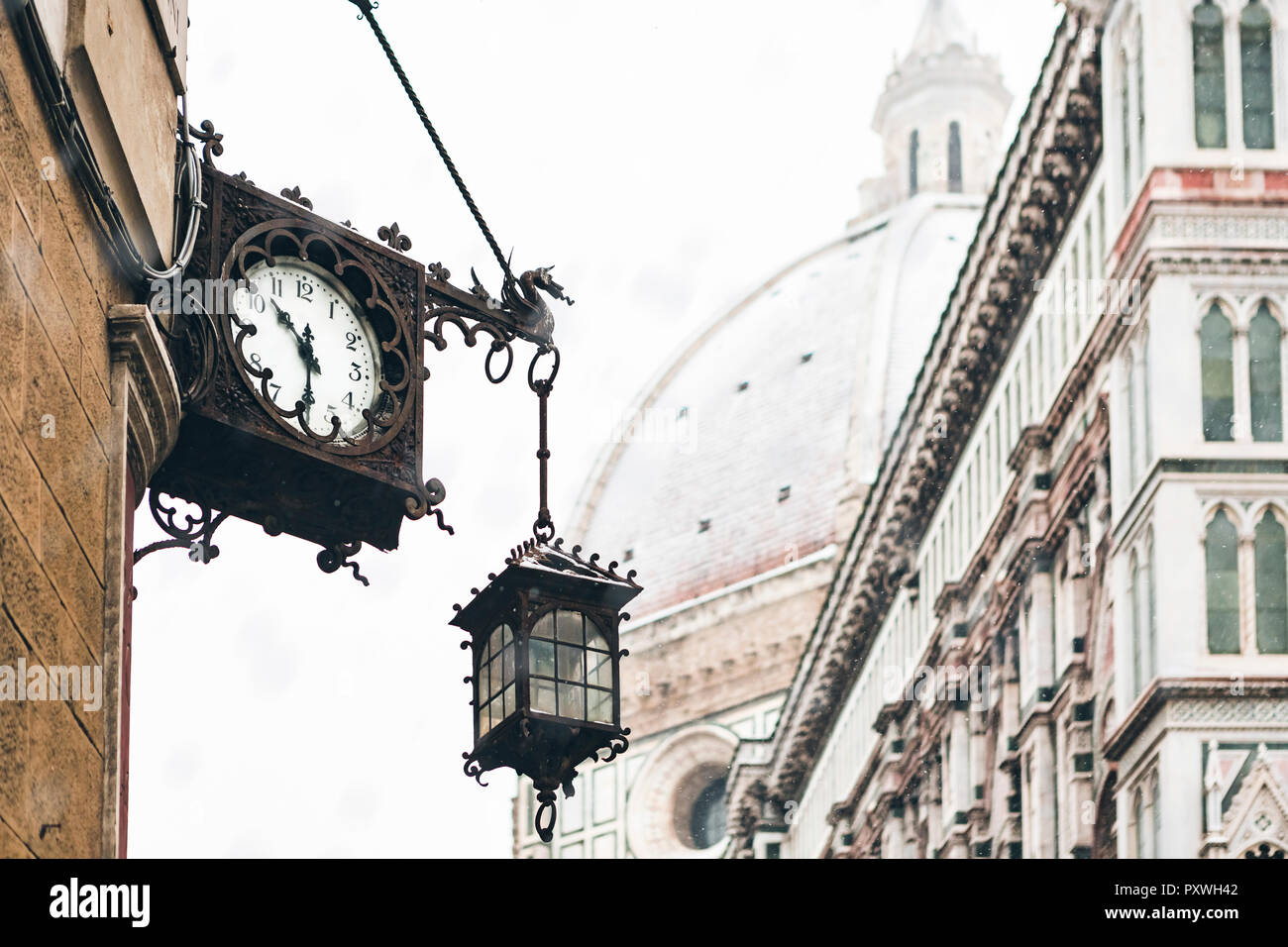 Italy, Florence, old clock and lantern at house front on winter Stock ...