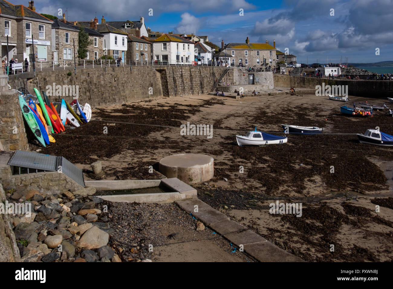 View of the traditional fishing village and harbour of Mousehole in ...