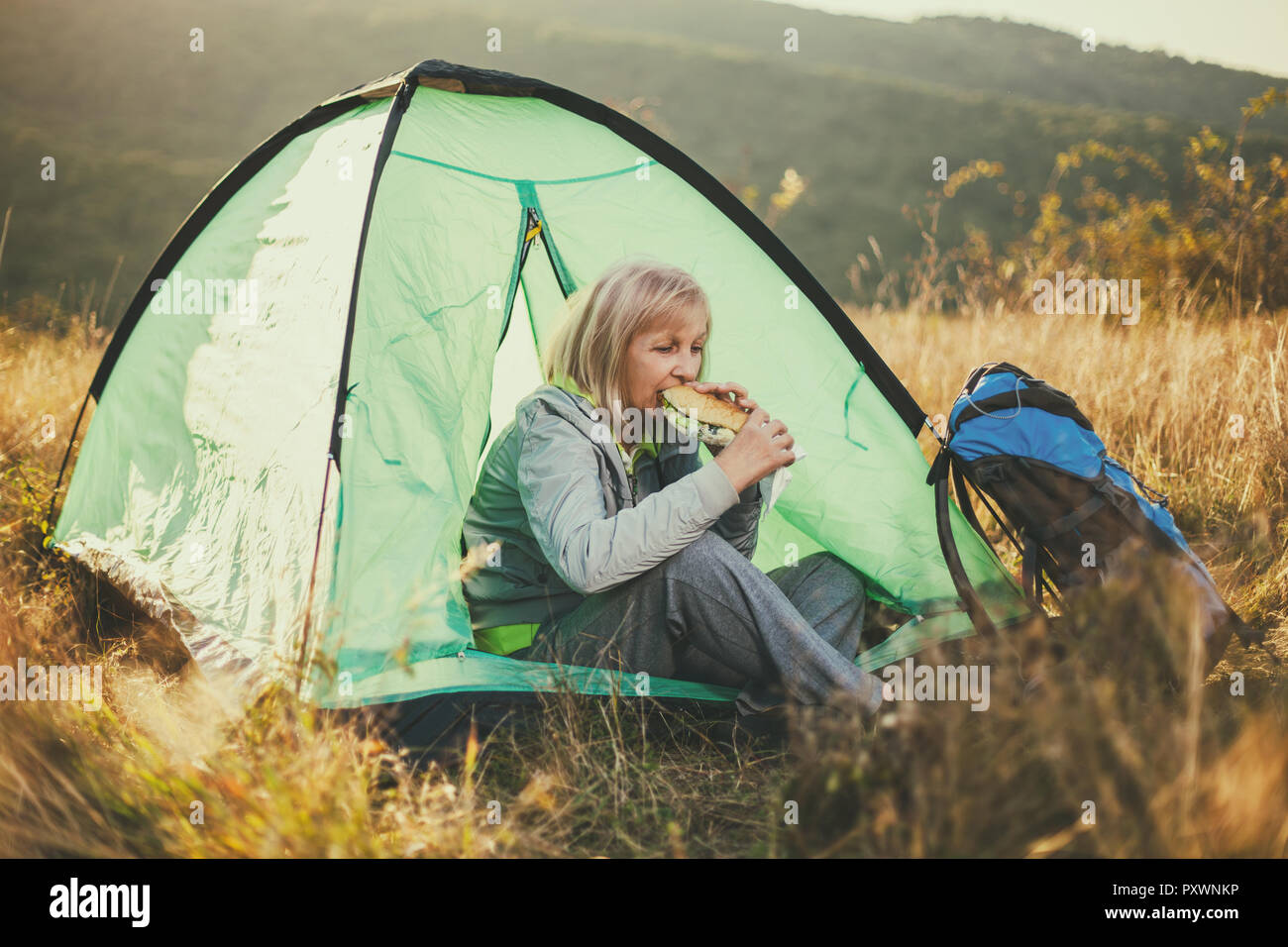 Senior woman is camping in mountain. Active retirement Stock Photo - Alamy