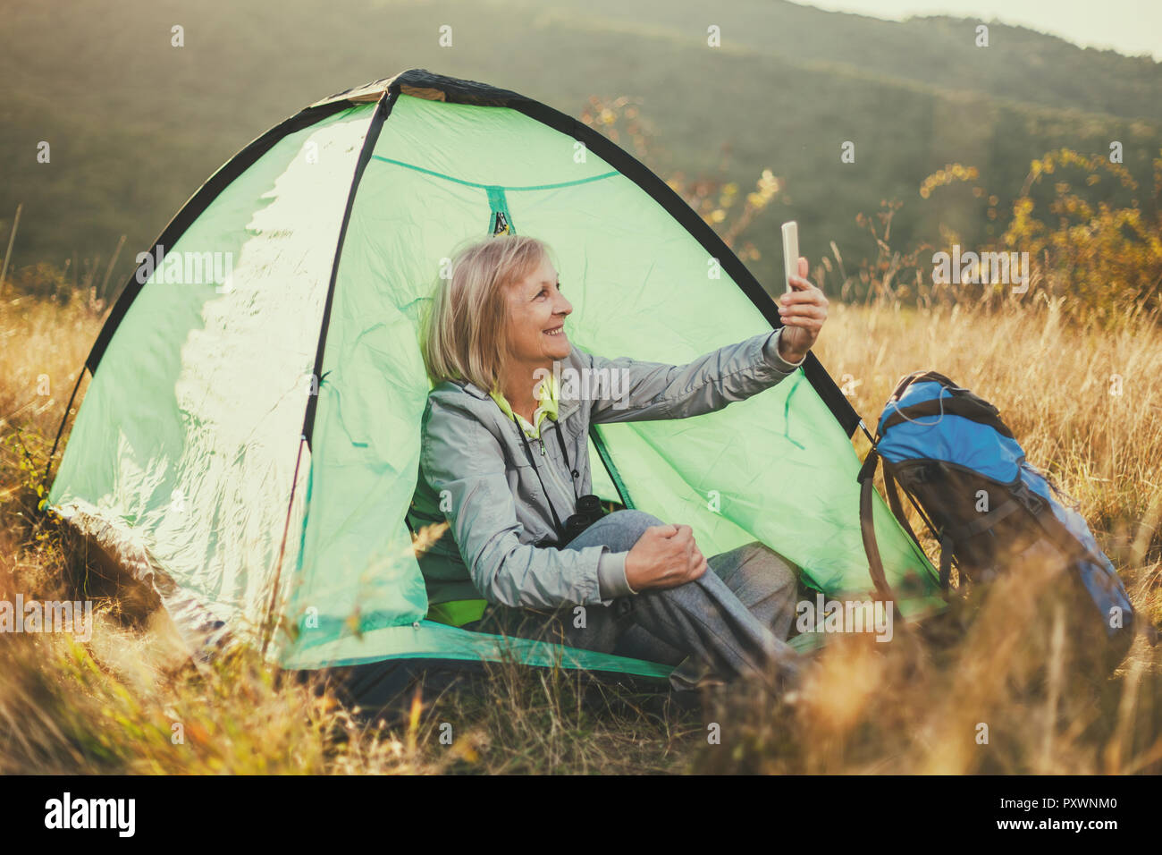 Senior woman is camping in mountain. Active retirement Stock Photo - Alamy