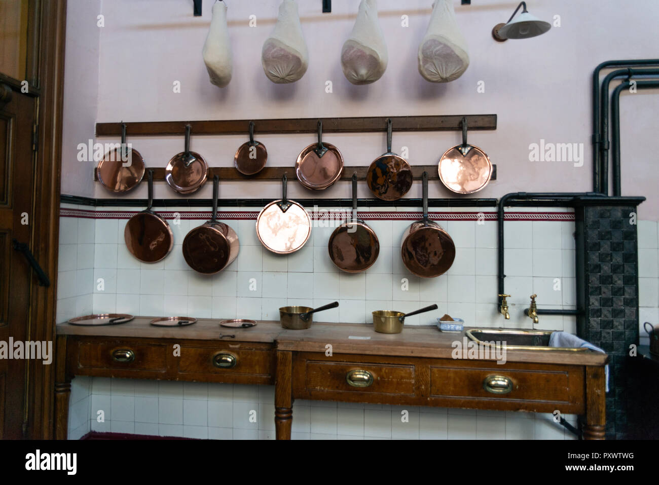 Timeless image of part of a Victorian kitchen with neat copper pans ...