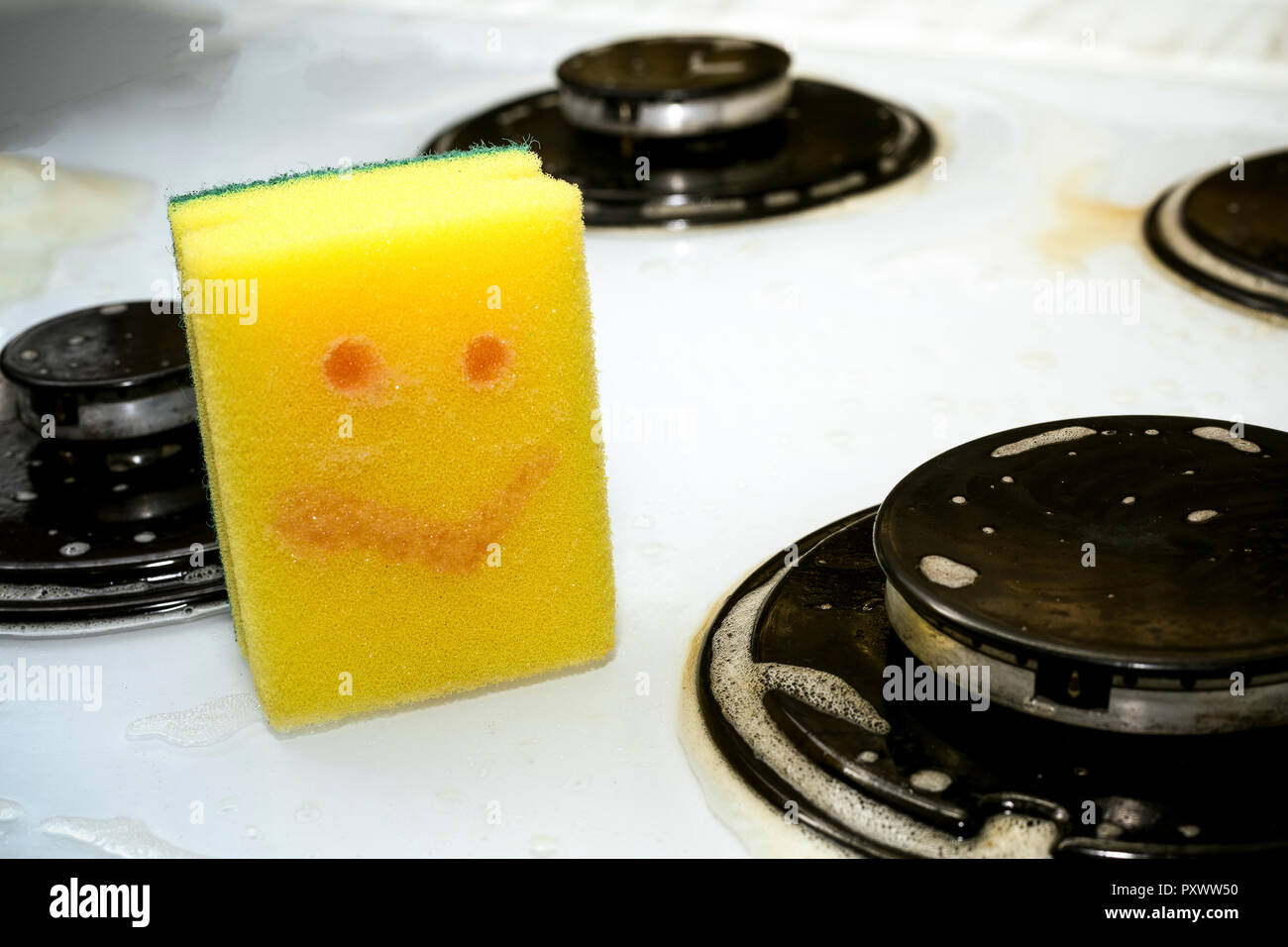 yellow sponge with painted smile, for dishes on dirty gas stove Stock ...