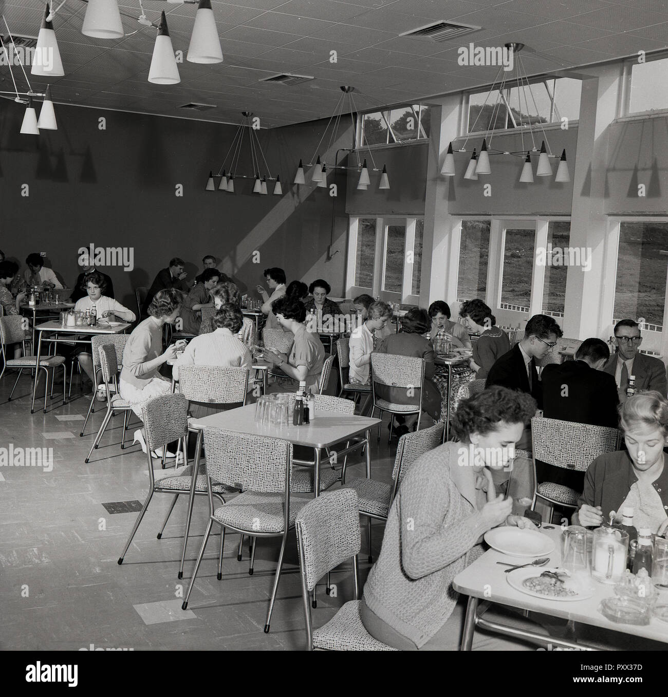 1960s, historical, employees sitting at tables having lunch together in ...
