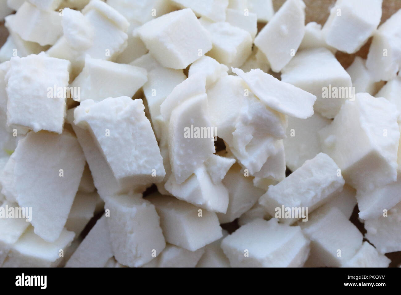 A close view of a minced stack of white mozzarella cheese dices ...