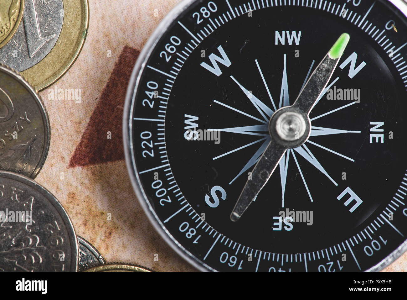 Close up of black compass with some coins Stock Photo - Alamy