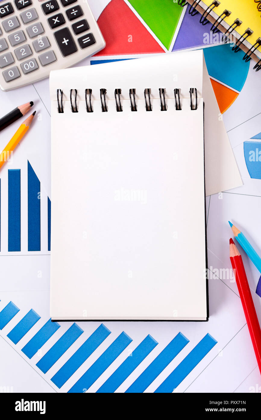 Blank folded notepad surrounded by various charts and graphs, pencils ...