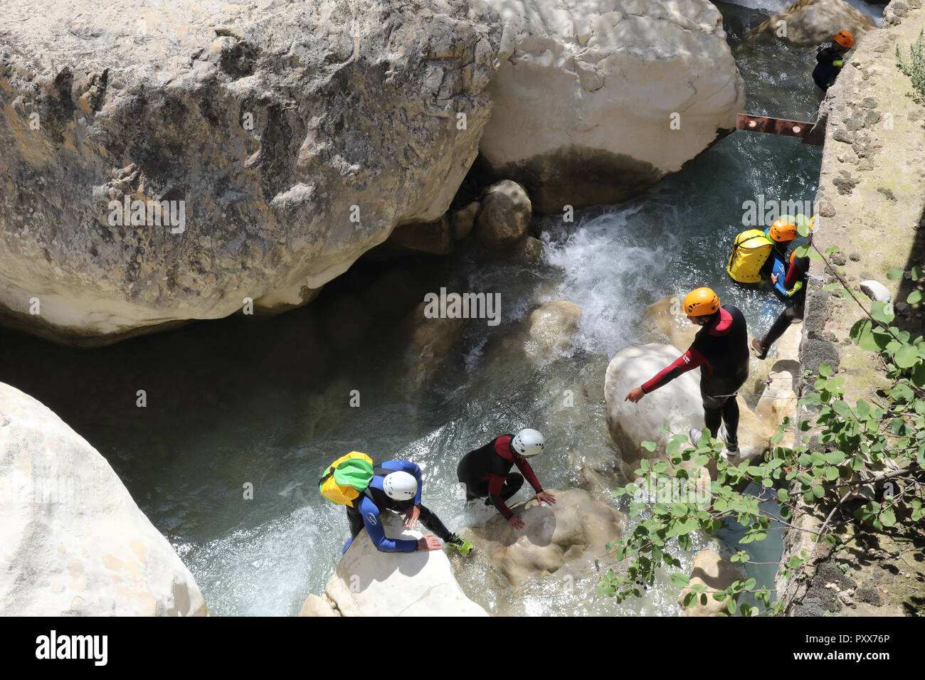 People practicing canyoning in the Vero river canyon, with helmets ...