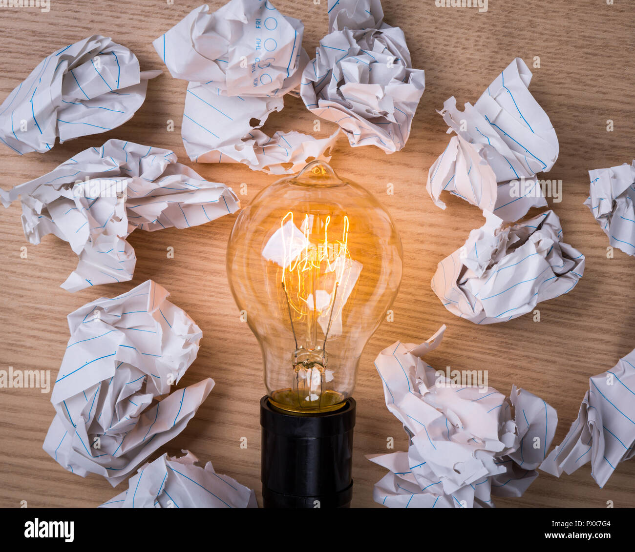 Light bulb with Crumpled paper on wood background Stock Photo - Alamy