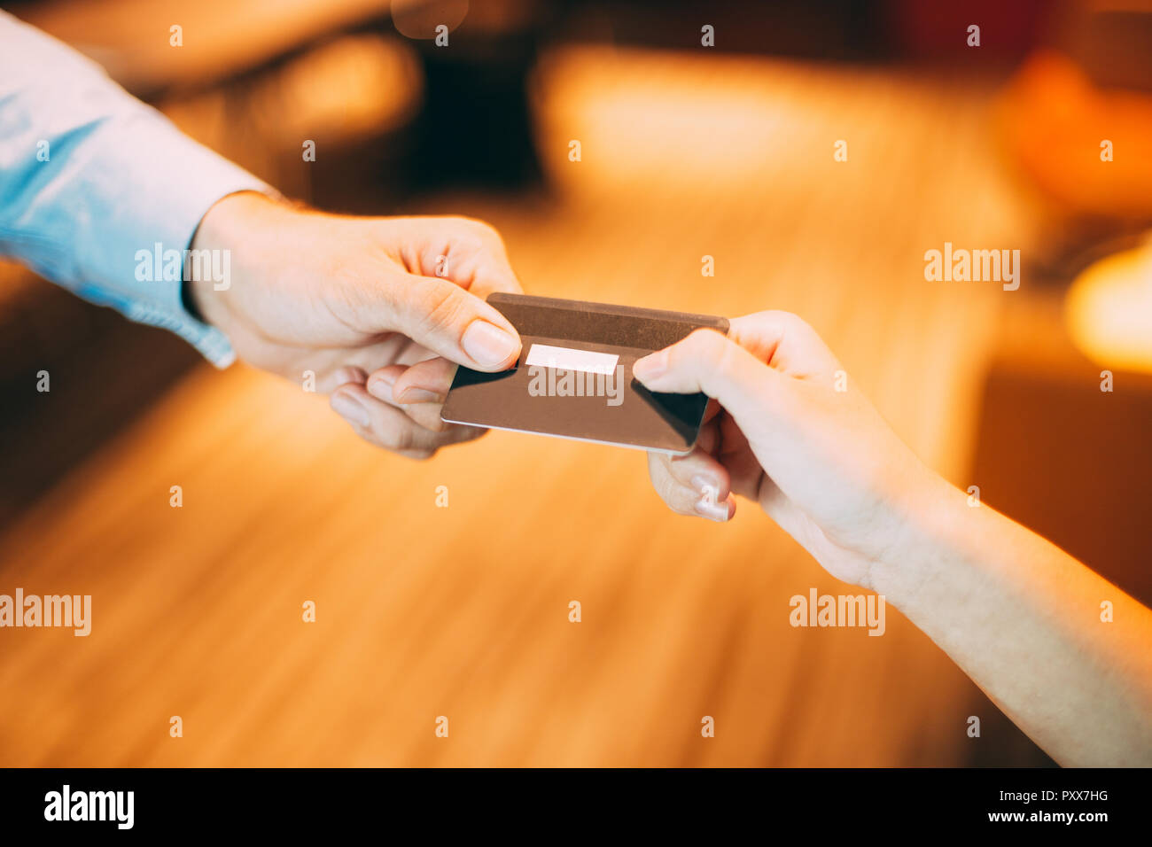 Male hand giving credit or debit card to female cashier for payment at ...