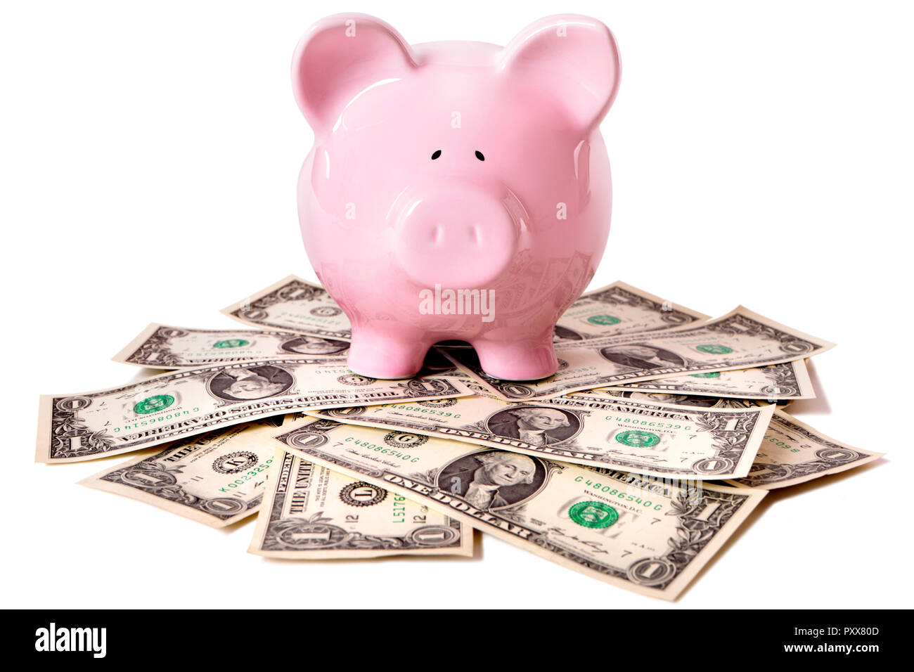 Pink piggy bank standing on an untidy pile of one dollar bills ...