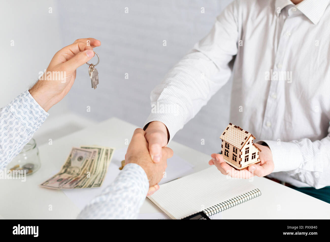 Realtor handshaking with unrecognizable client Stock Photo - Alamy