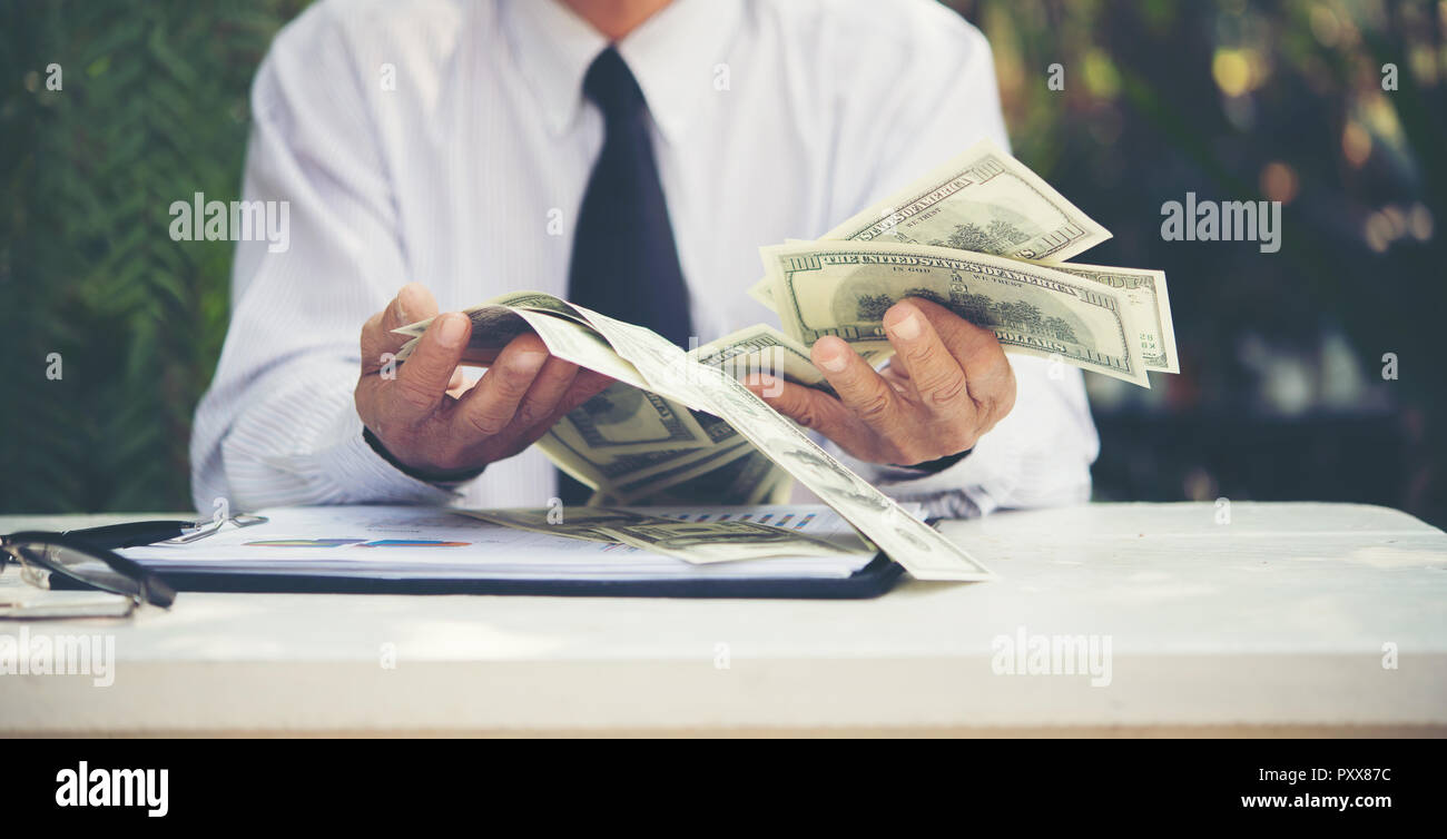Senior businessman counting U.S. dollar bills Stock Photo - Alamy