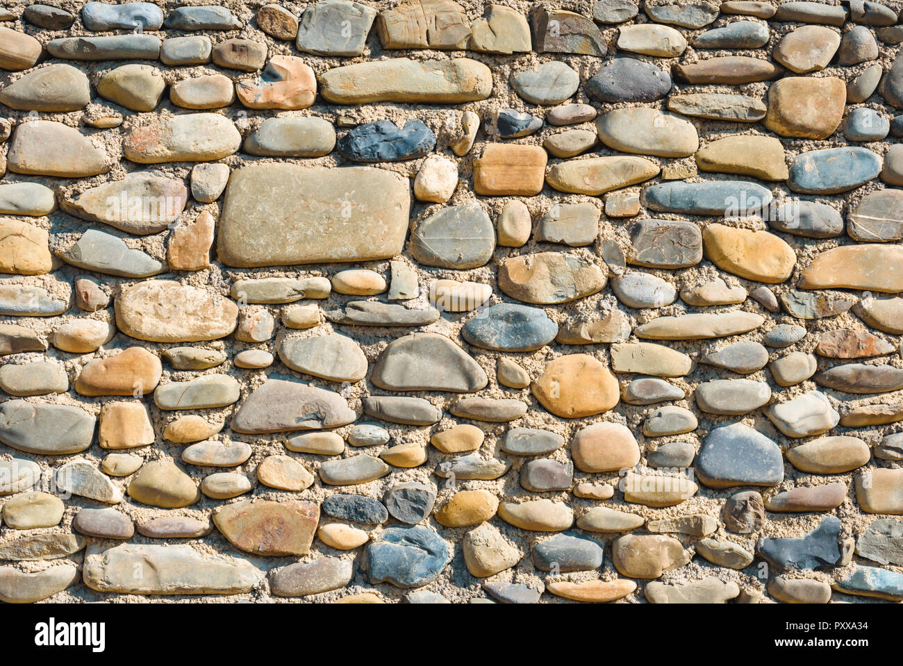 Ancient wall from big colourful round stones Stock Photo - Alamy