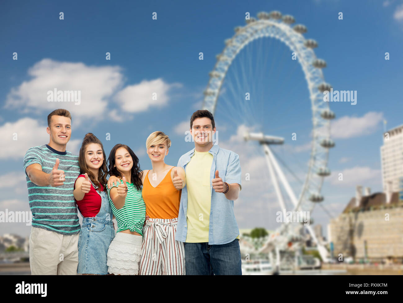 friends showing thumbs up over ferry wheel Stock Photo - Alamy