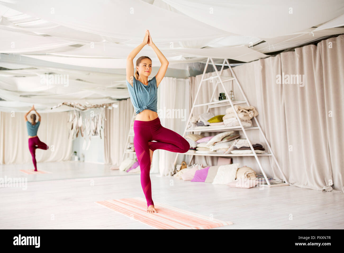 young woman doing yoga tree pose at studio Stock Photo - Alamy