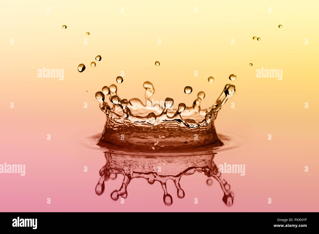 Colorful water splash in shape of crown. Pink and yellow tone image ...