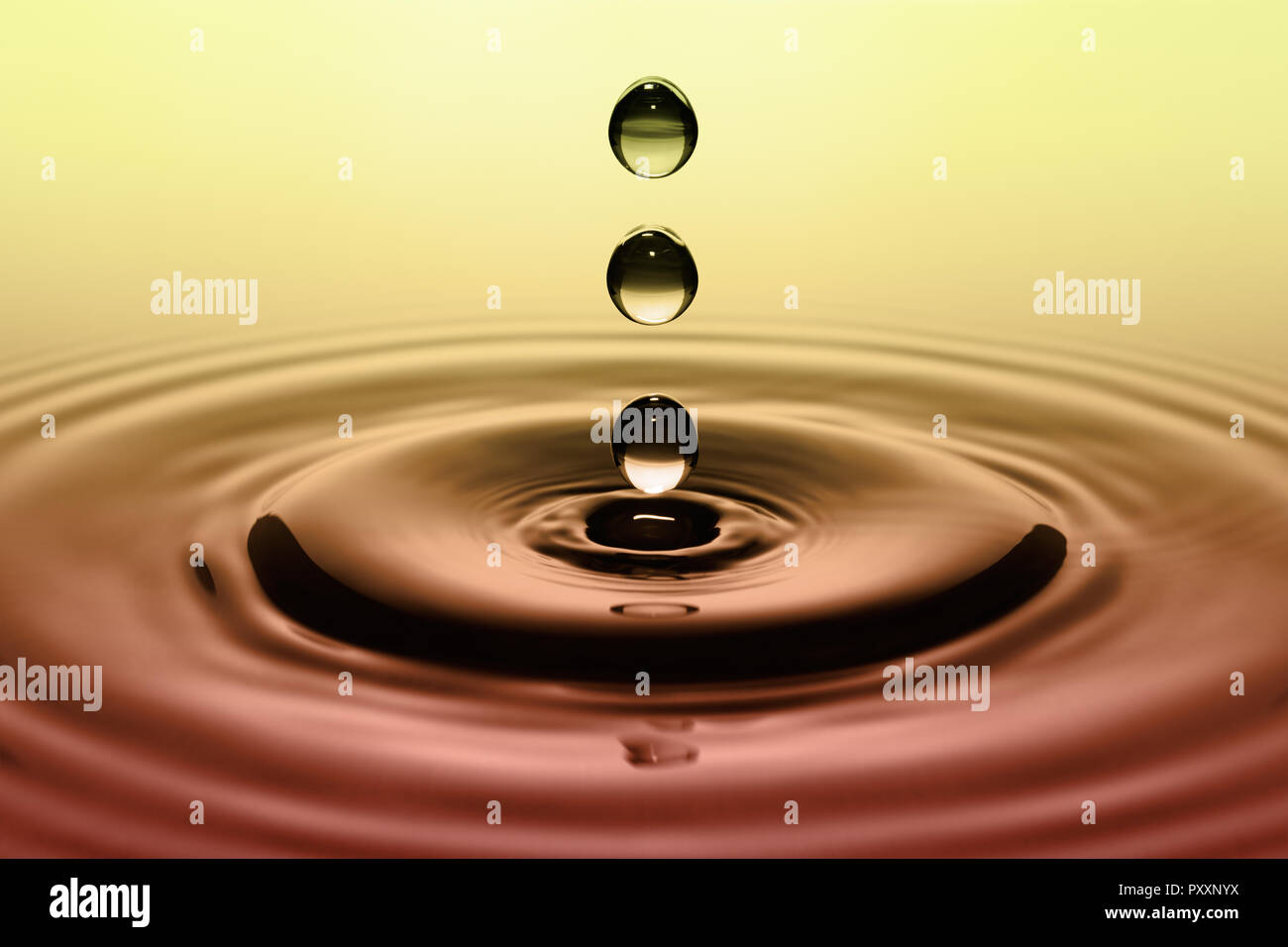Drop of rain falling to smooth water surface. Picture in red tone Stock ...