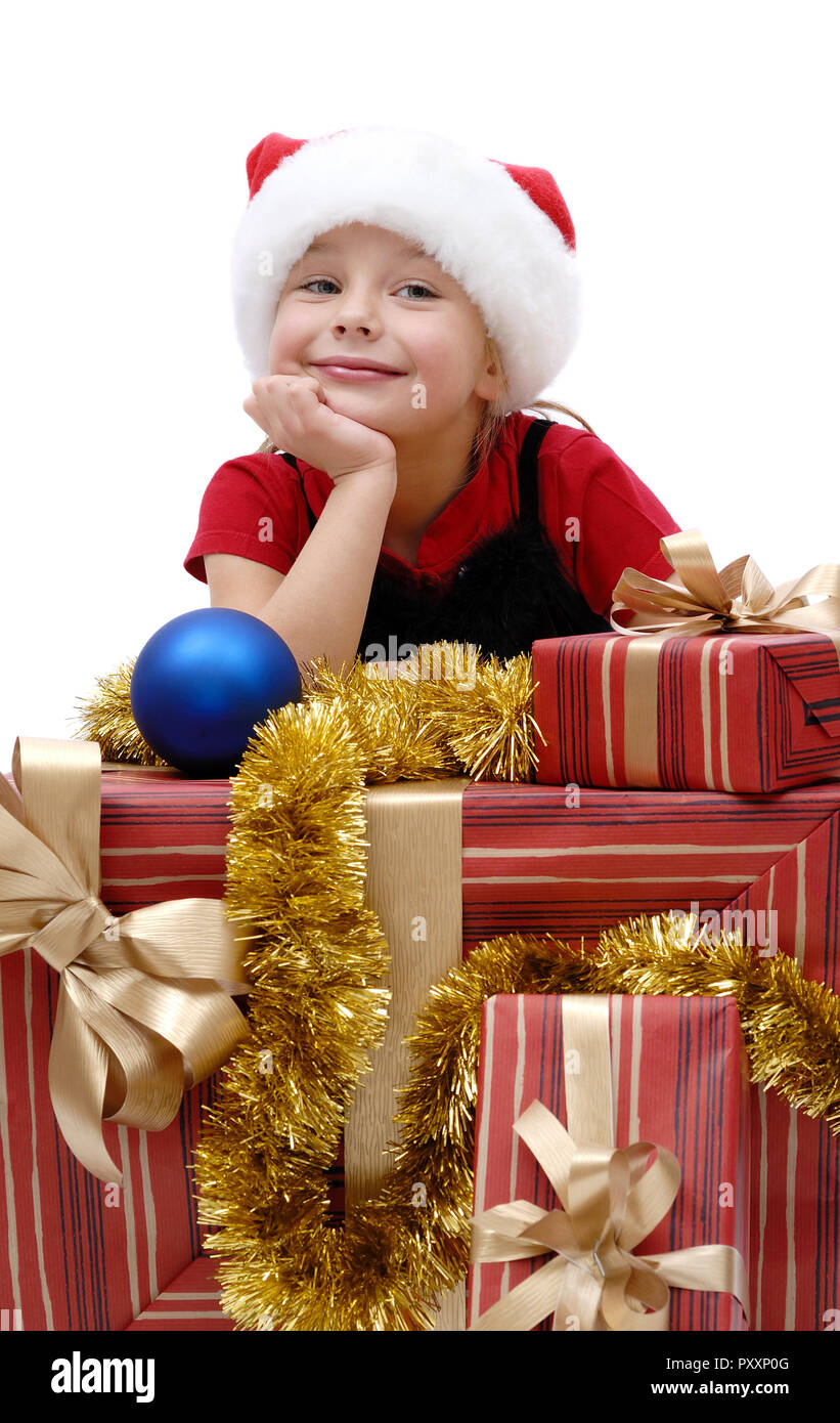 Cute little girl in a Santa Claus cap with Christmas gifts on a white ...
