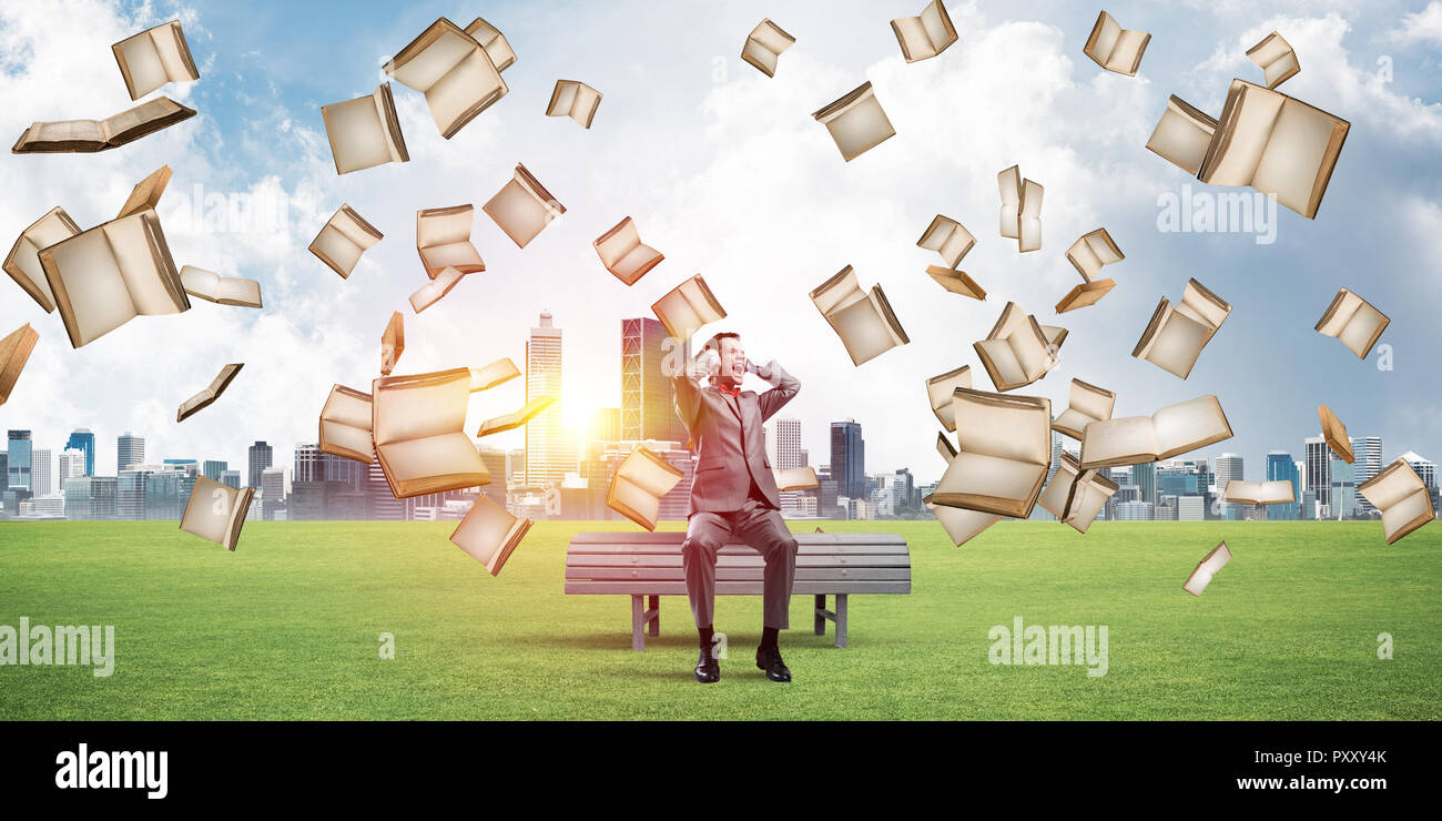Many old books falling from above and student guy sitting on bench ...