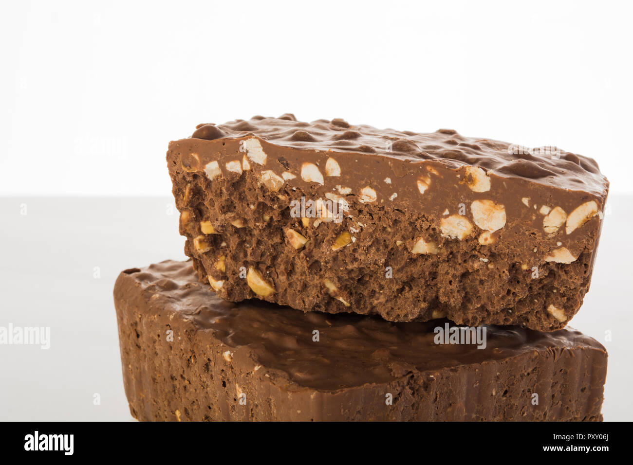 Big bar of milk chocolate with nuts on white background with copy space ...
