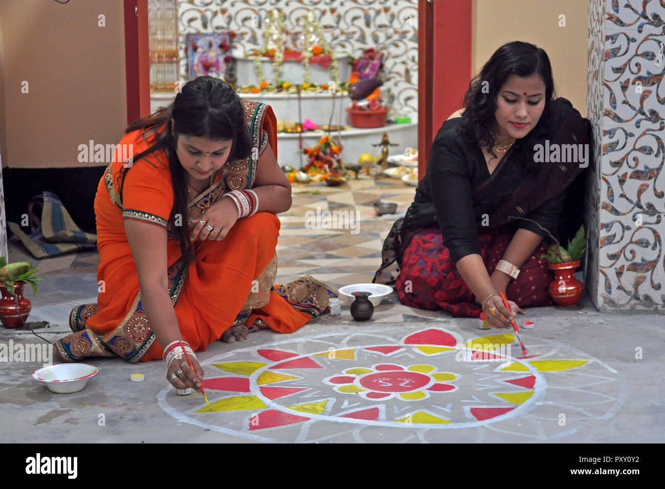 Indian women busy to paint Alpona traditional religious art on the occasion of Laxmi Puja ...