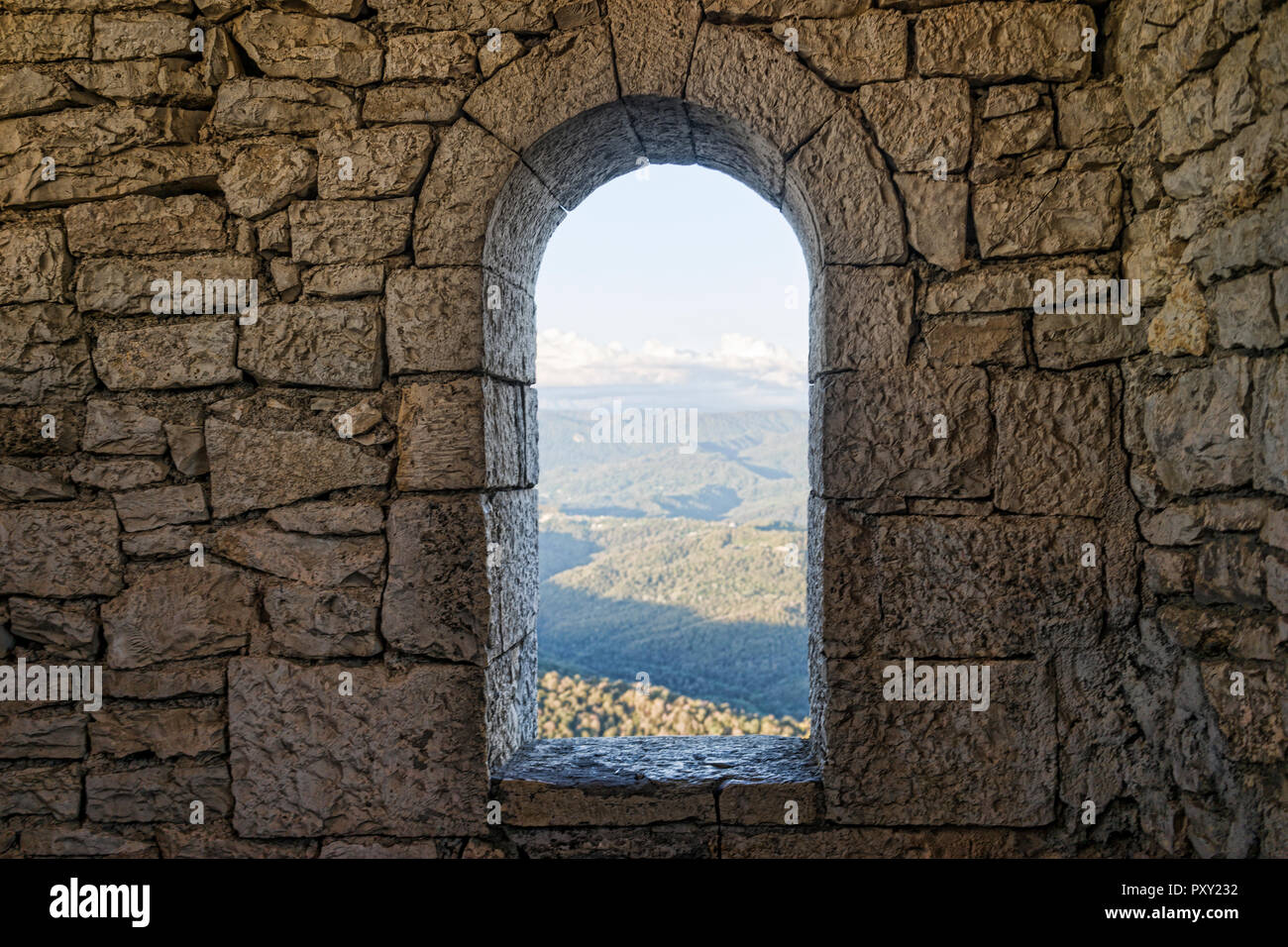 A window in a stone wall overlooking a mountain landscape Stock Photo ...