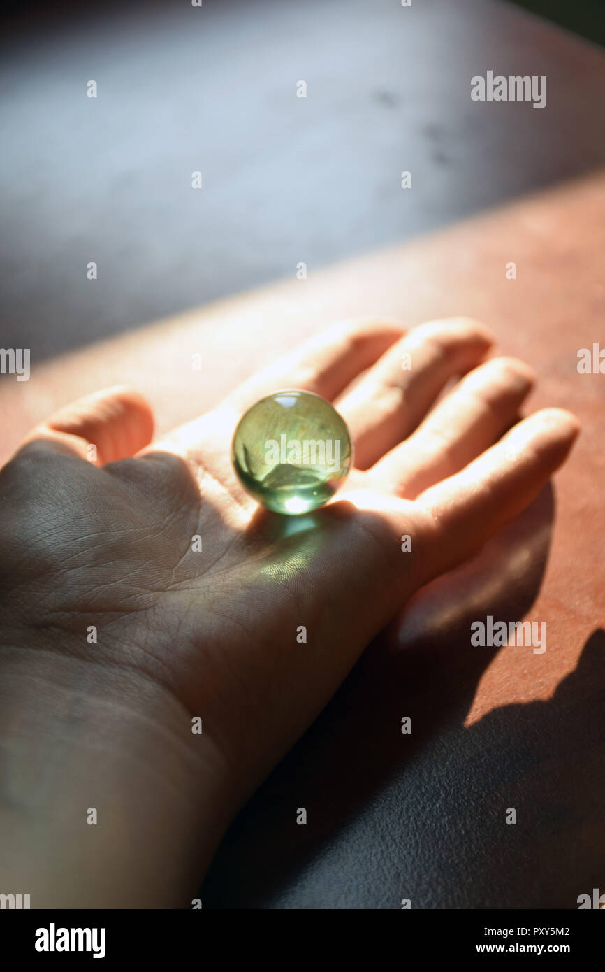 Hand holding a marble ball on a direct sunlight Stock Photo - Alamy