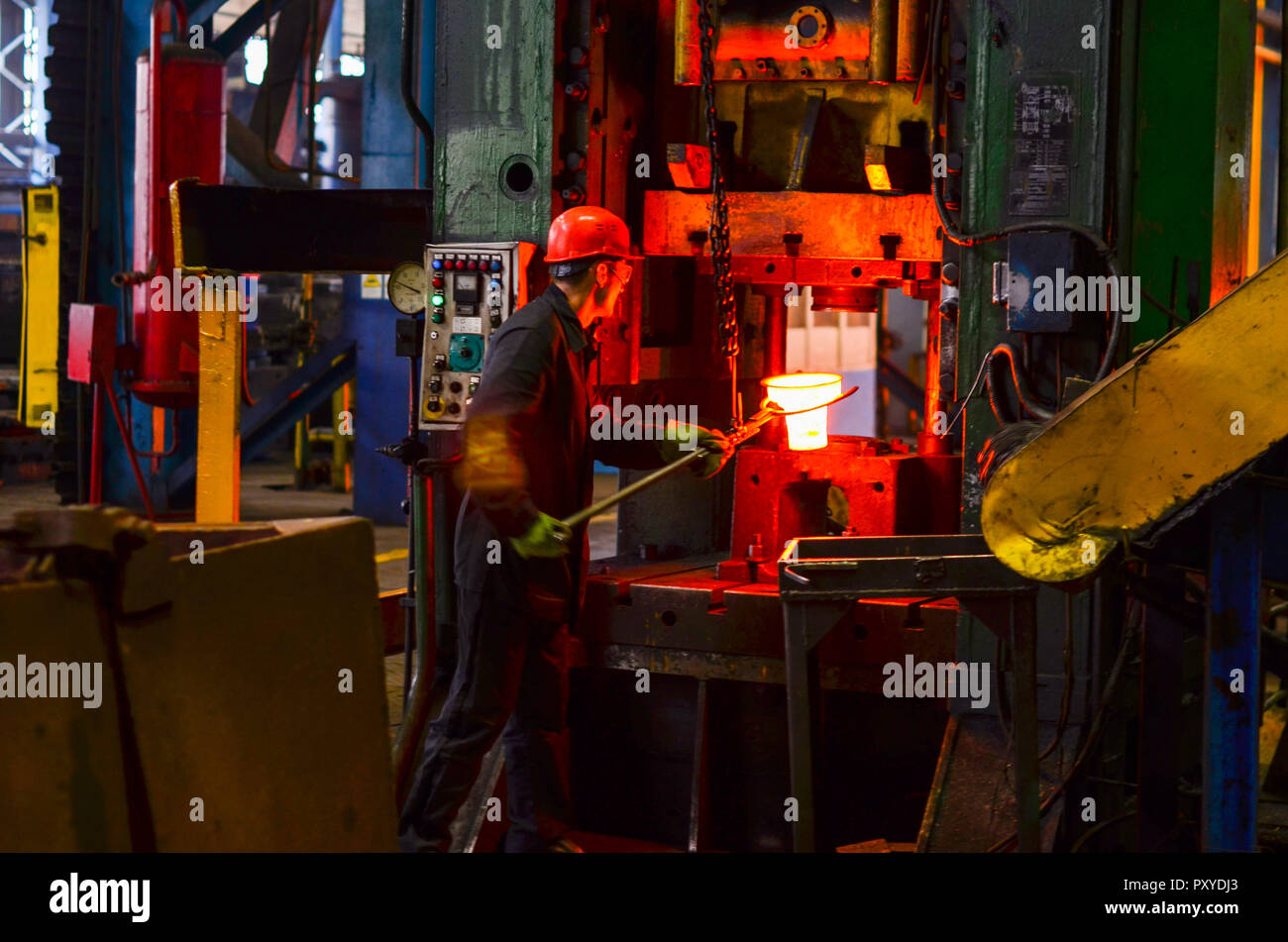 Hot iron in smeltery held by a worker. High precision hot forging ...