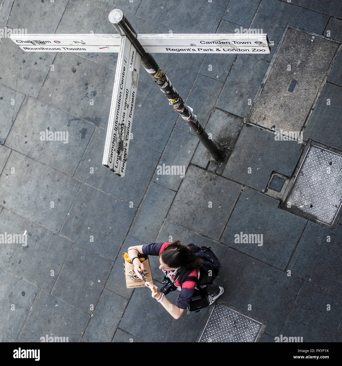 birds eye view on pedestrians using mobile phones beside street sign ...