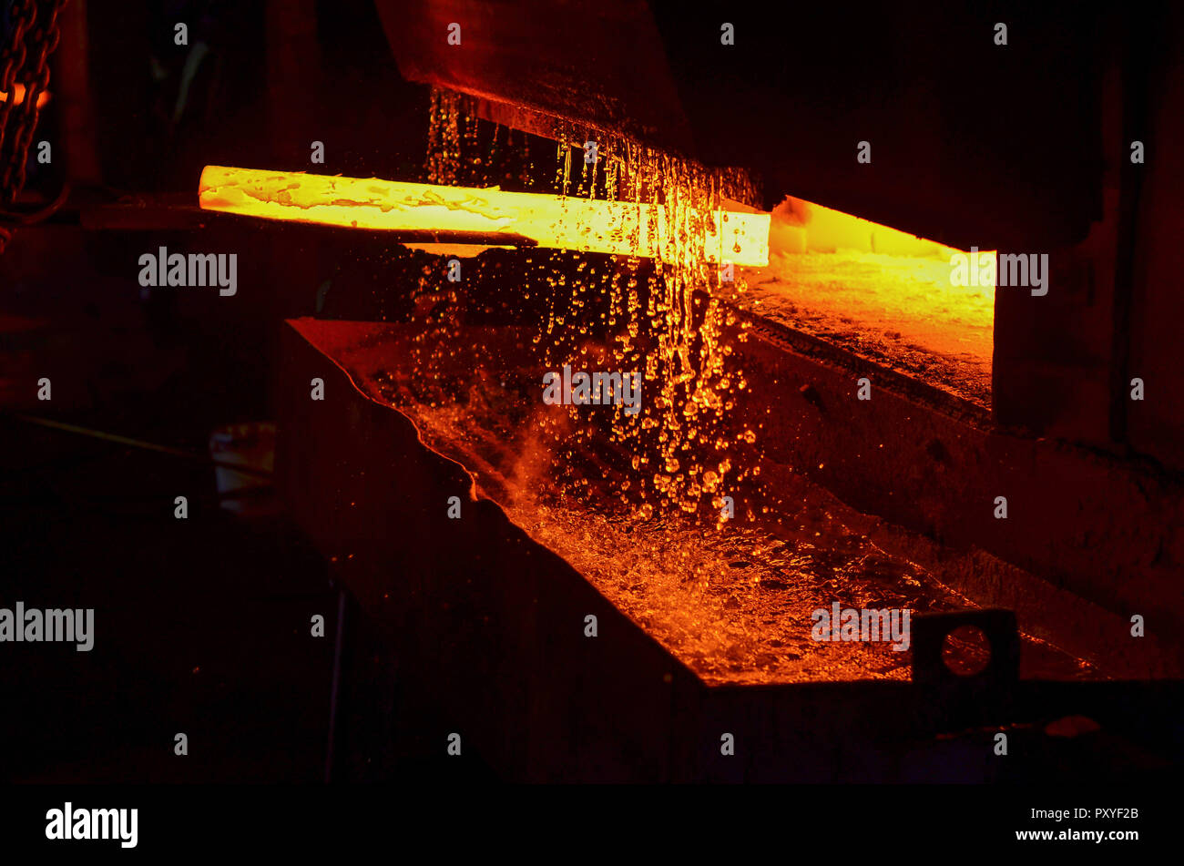 Hot iron in smeltery held by a worker. Iron melting recycling work ...