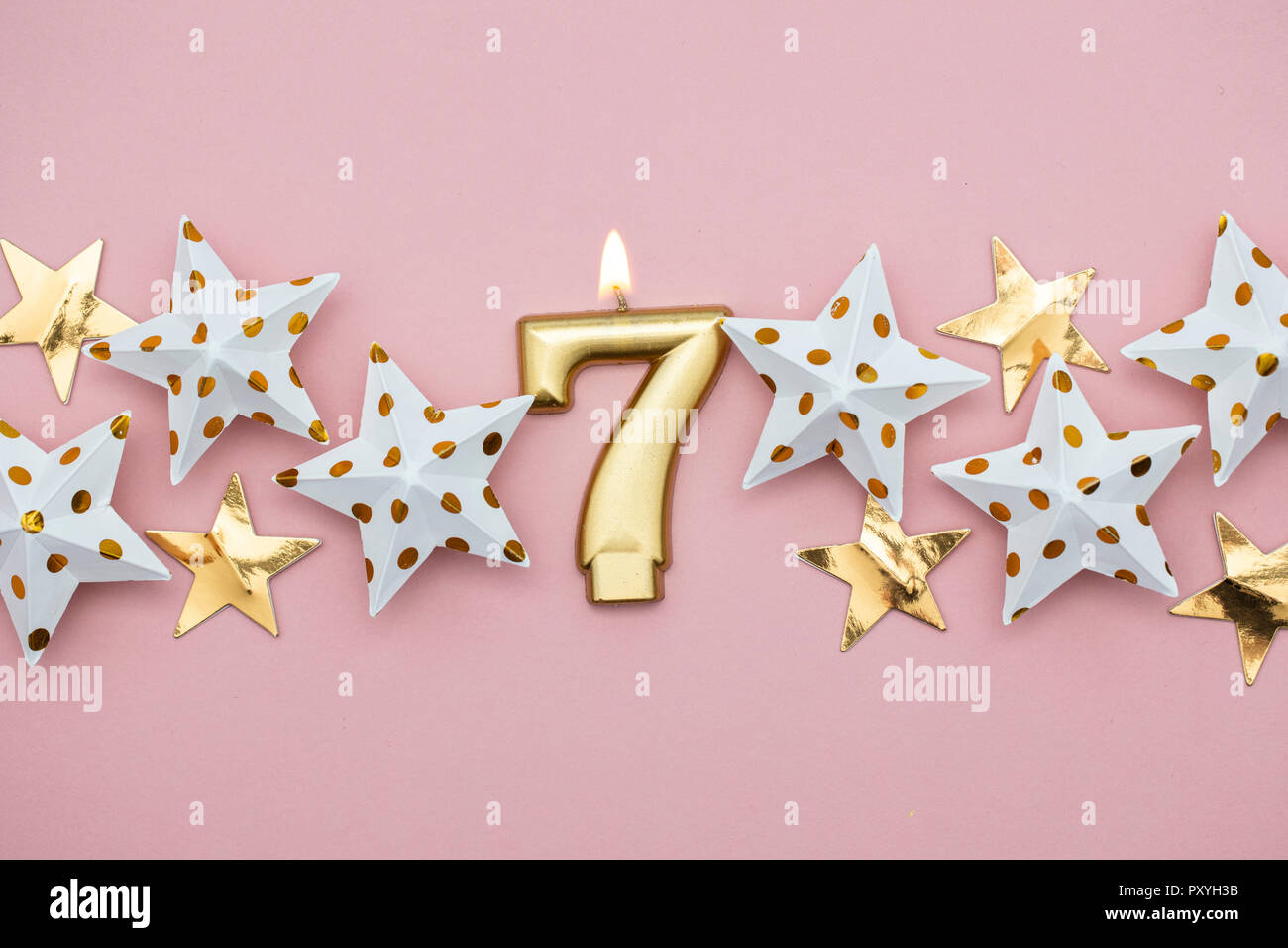 Number 7 gold candle and stars on a pastel pink background Stock Photo ...