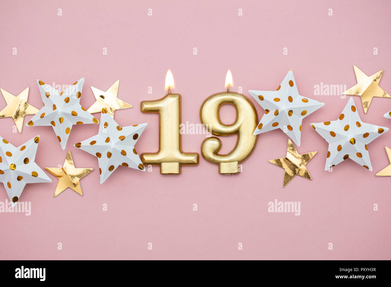 Number 19 gold candle and stars on a pastel pink background Stock Photo ...