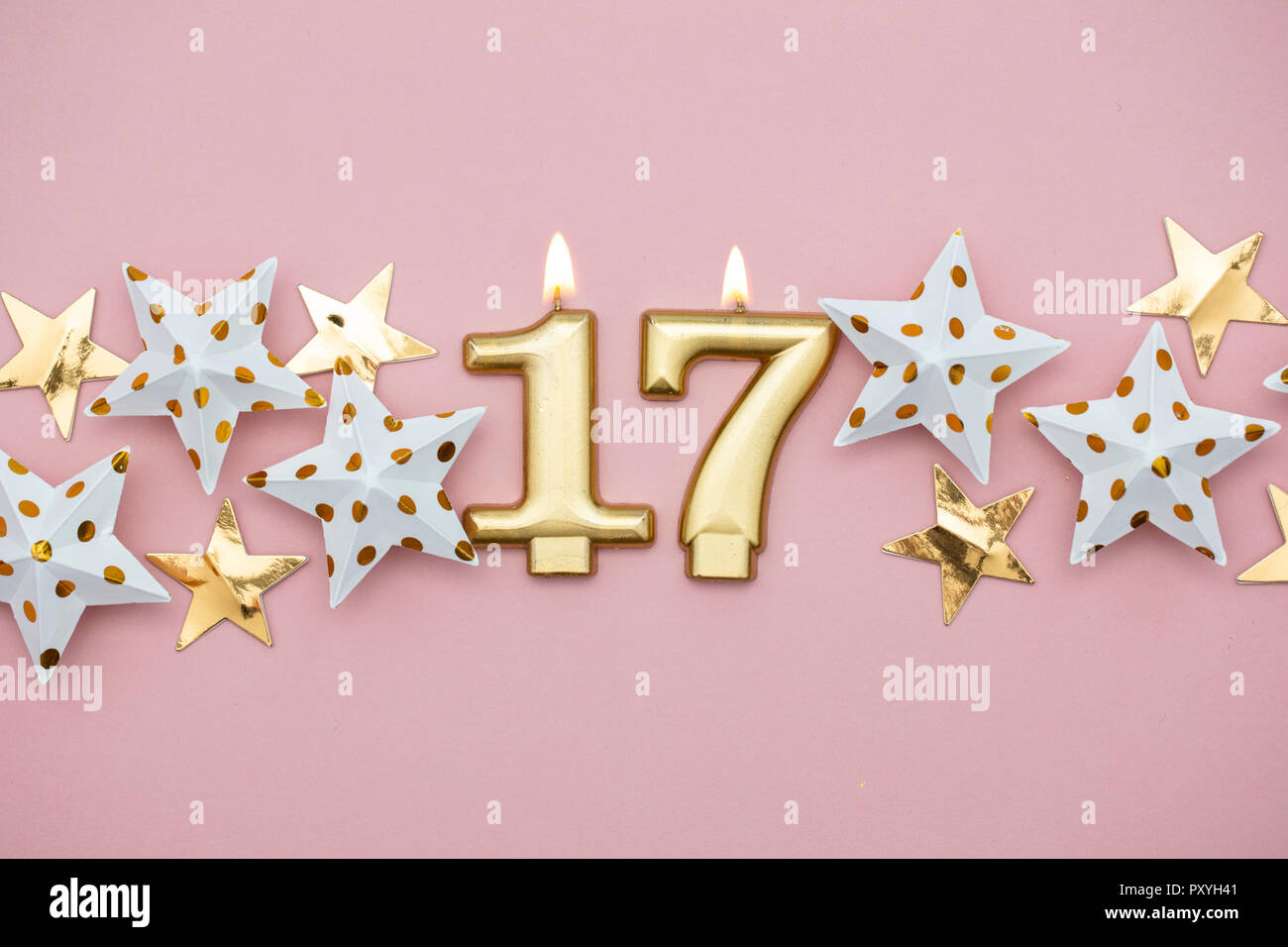Number 17 gold candle and stars on a pastel pink background Stock Photo ...