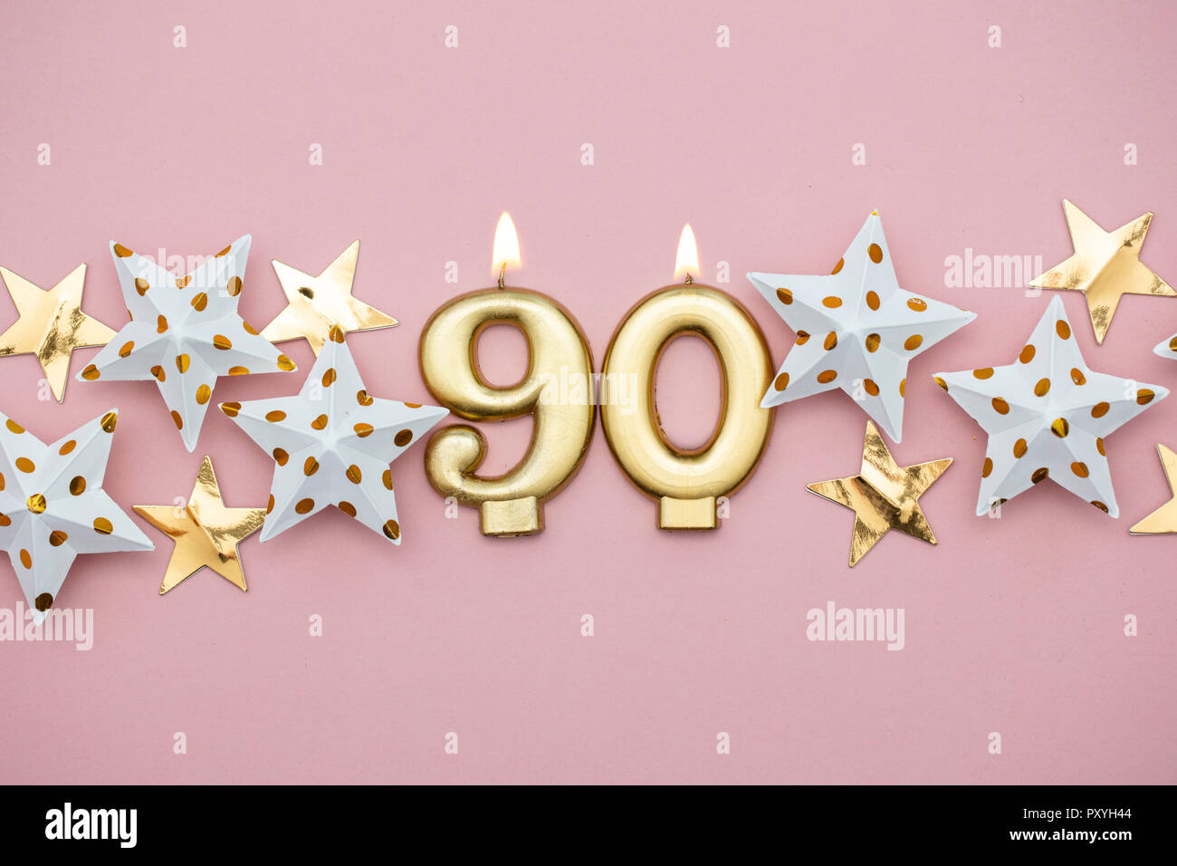 Number 90 gold candle and stars on a pastel pink background Stock Photo ...