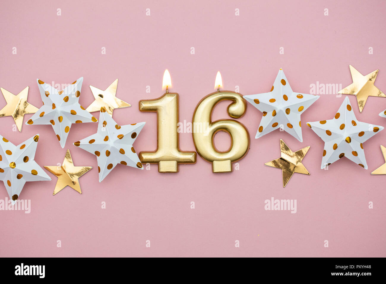 Number 16 gold candle and stars on a pastel pink background Stock Photo ...
