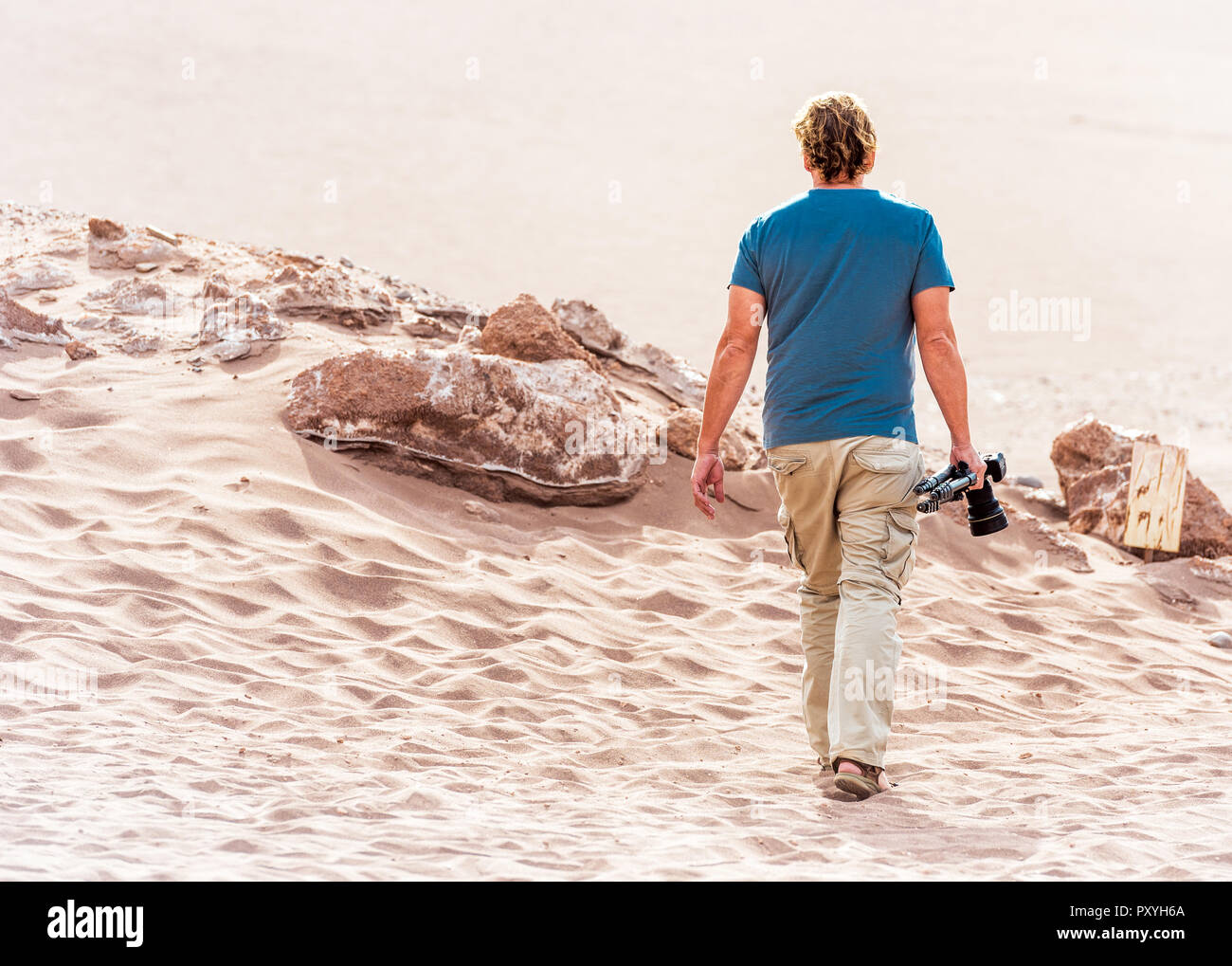 A man with a camera in the desert, Moon Valley, Chile. Back view Stock ...