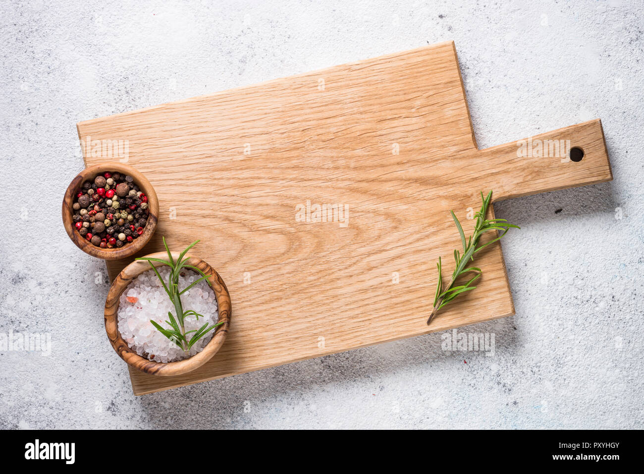 Wooden cutting board with sea salt and pepper on white stone tab Stock ...