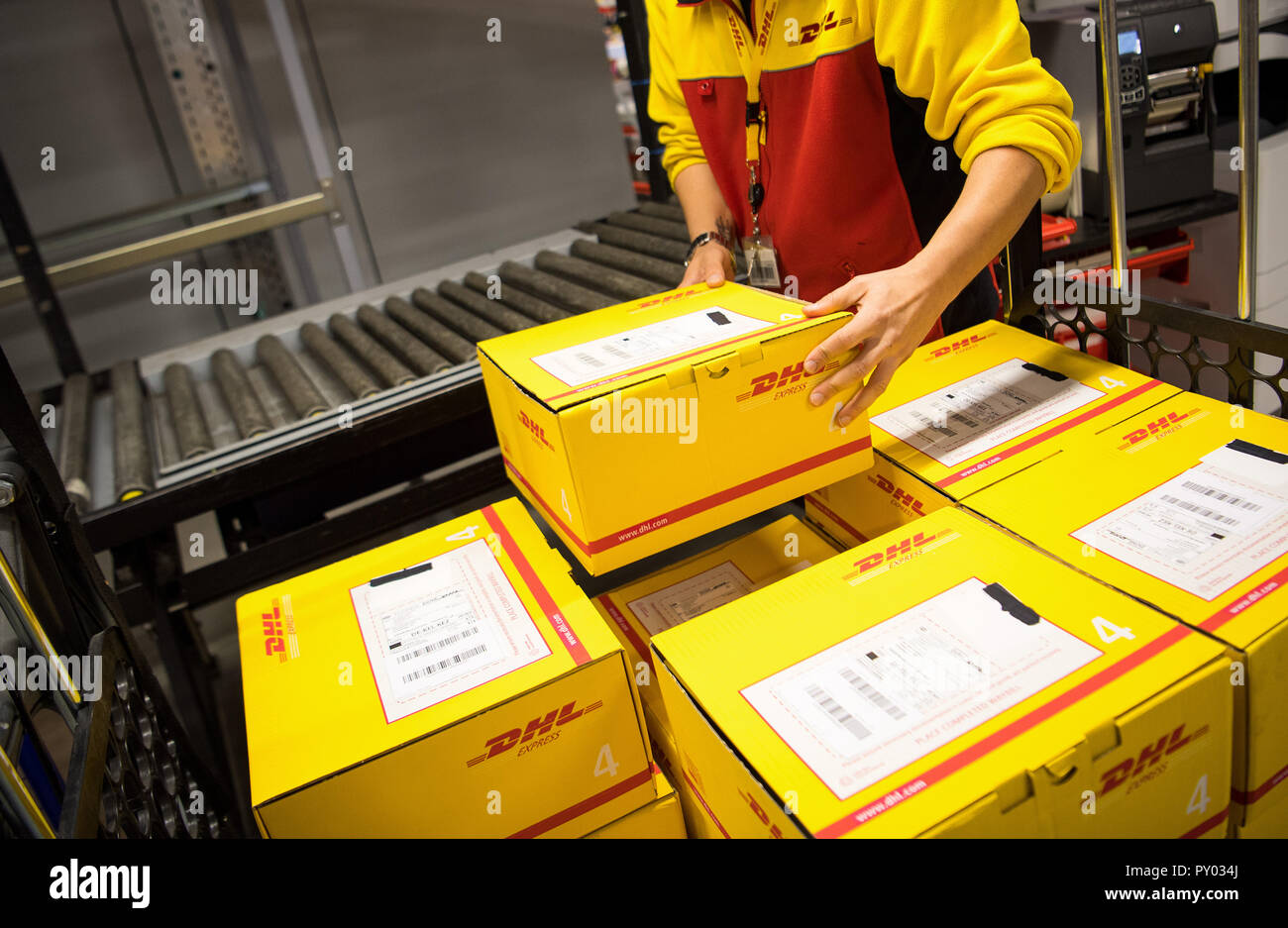 25 October 2018, Saxony, Klipphausen: An employee puts parcels on the ...