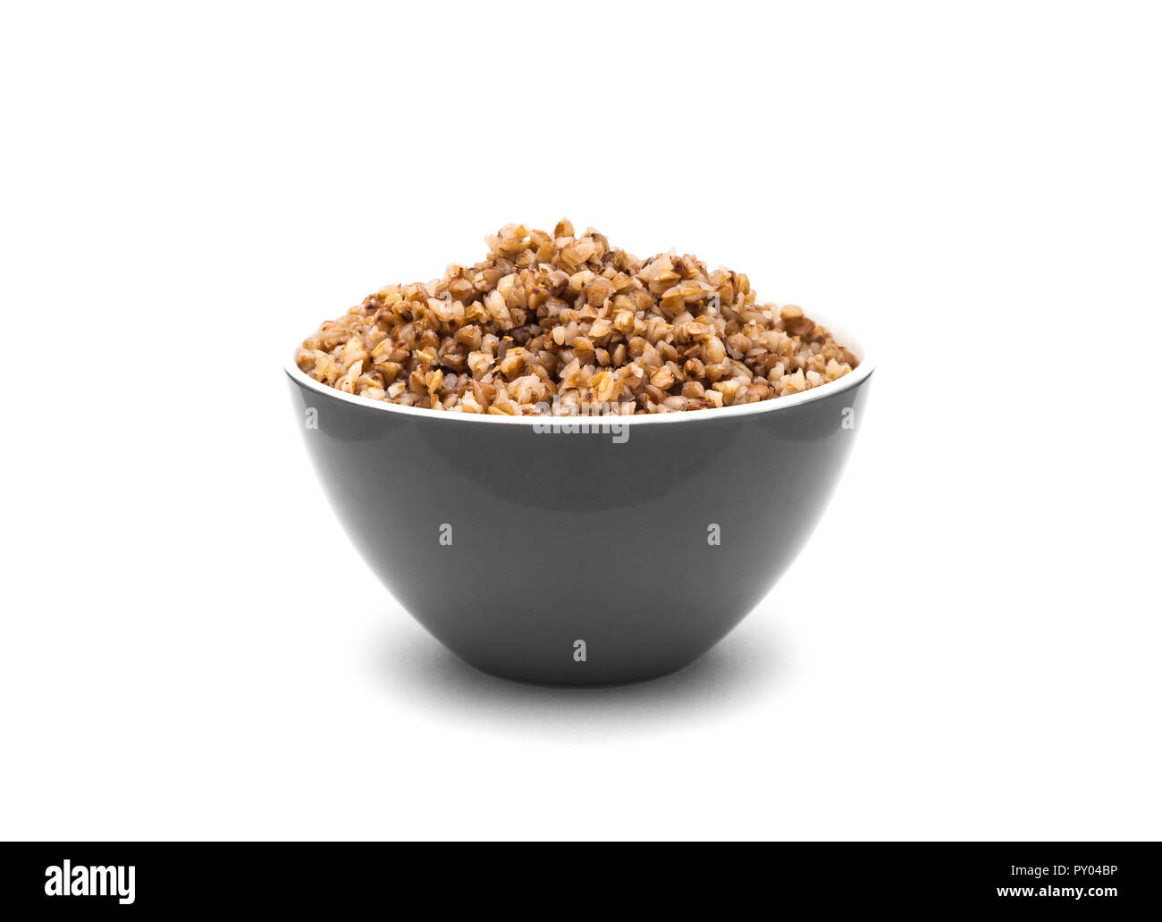 Dry buckwheat in grey color ceramic bowl isolated on white background ...