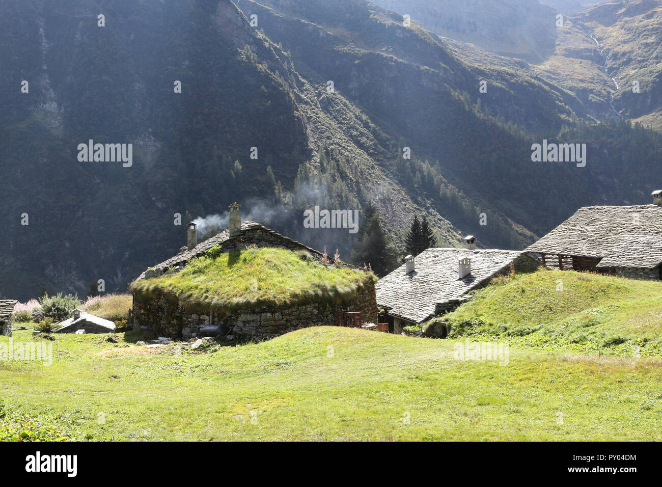 The Walser town of Dorf, with wood and stone lodges, high mountains ...