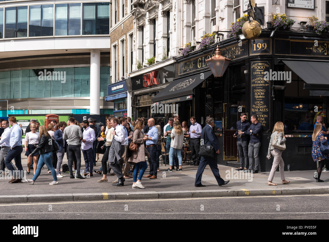 People standing outside The Globe pub as pedestrians walk past, London ...