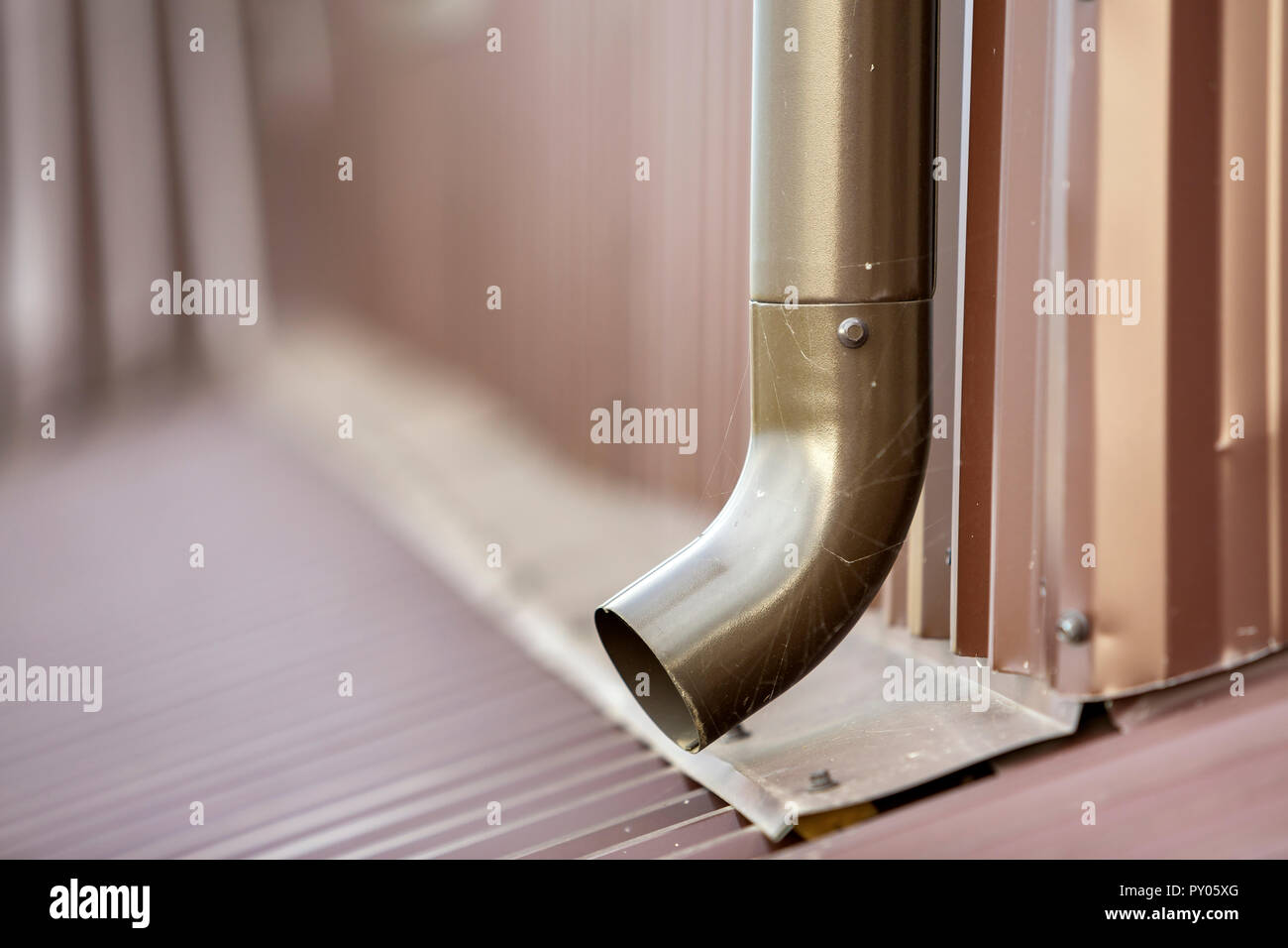 Close-up of brown new gutter metal system pipe on blurred copy space ...