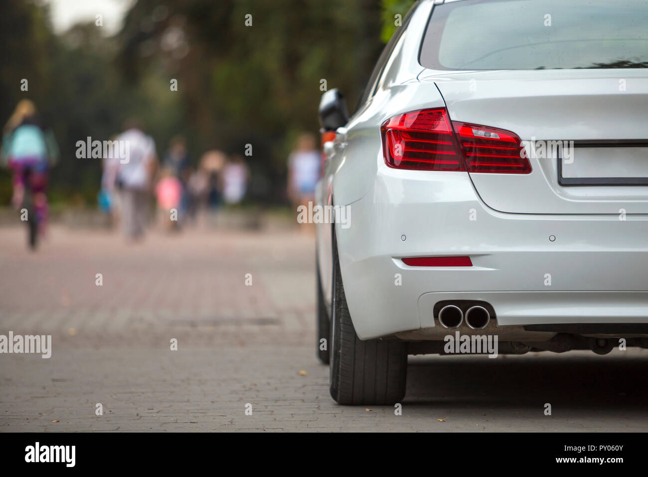 Back view part of white car parked on city pedestrian zone pavement on ...