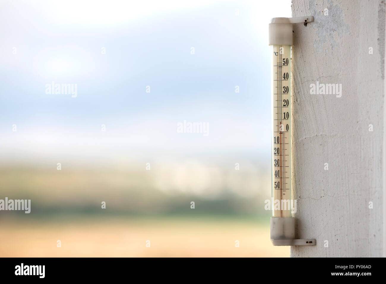 Traditional alcohol glass thermometer Celsius attached to plastered ...