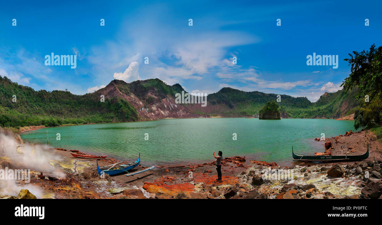 Woman taking picture in front of Taal Volcano crater lake and mountains ...