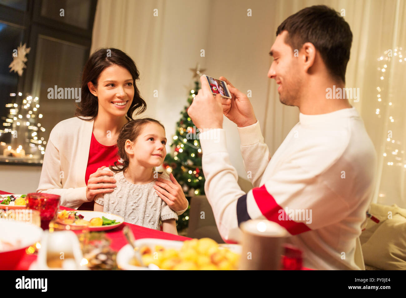 happy family taking picture at christmas dinner Stock Photo - Alamy